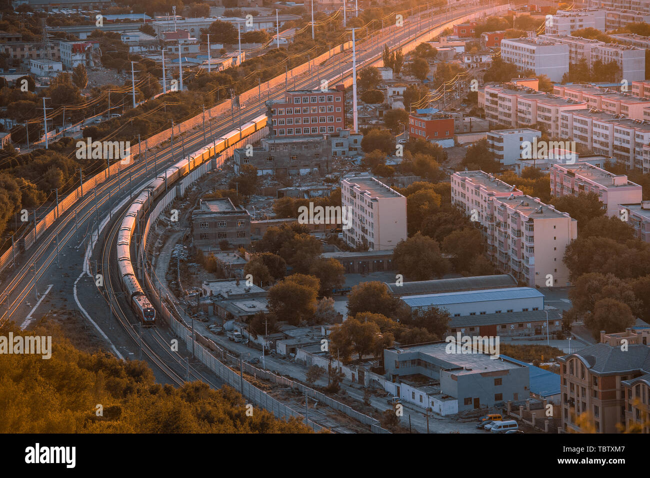 City rail train crosses Urumqi Stock Photo - Alamy
