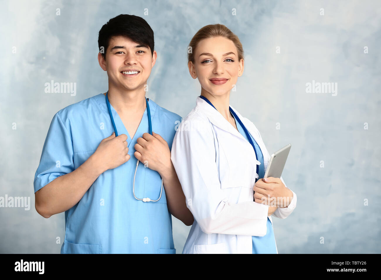 Portrait of female doctor and male medical assistant on color ...