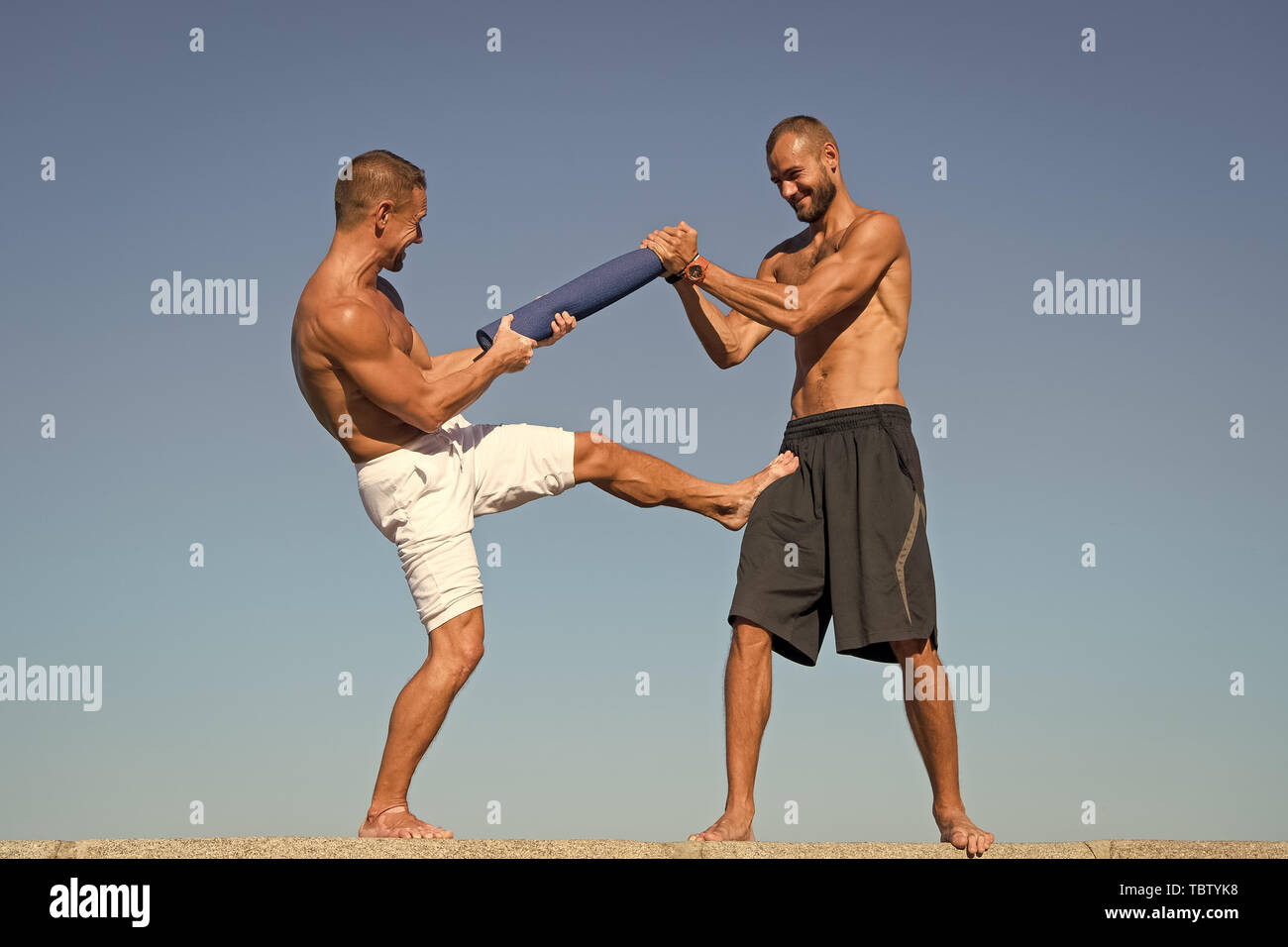 Men with yoga mat captured in motion blue sky background. Sportsman ...