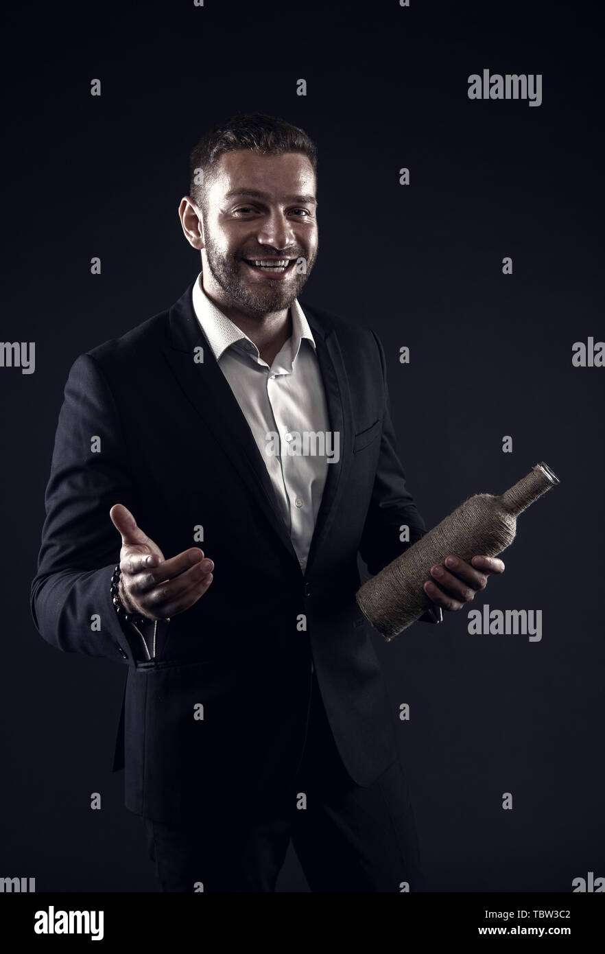 Restaurateur at grand opening of new place. Man holding vintage bottle ...