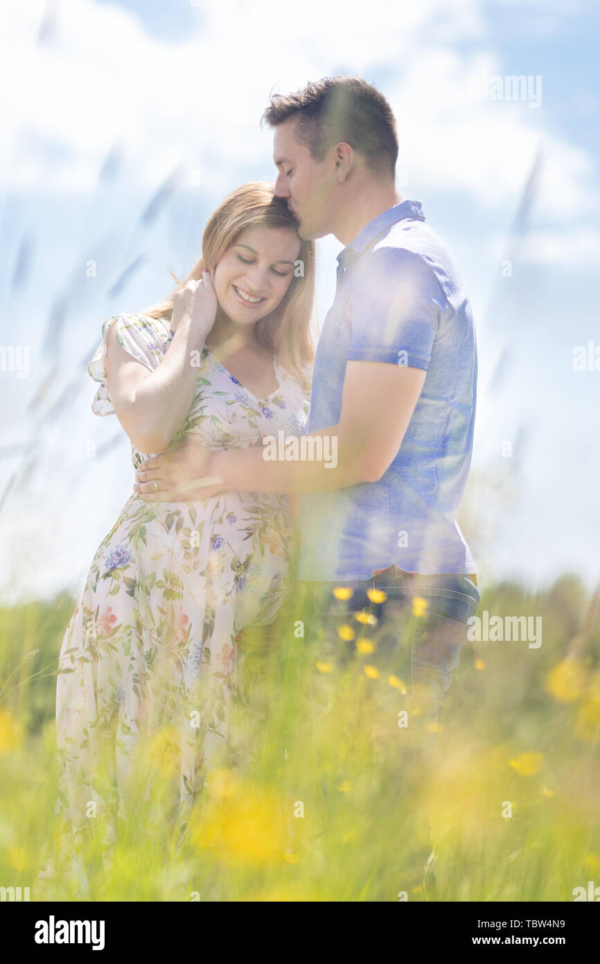 Young happy pregnant couple hugging in nature Stock Photo - Alamy
