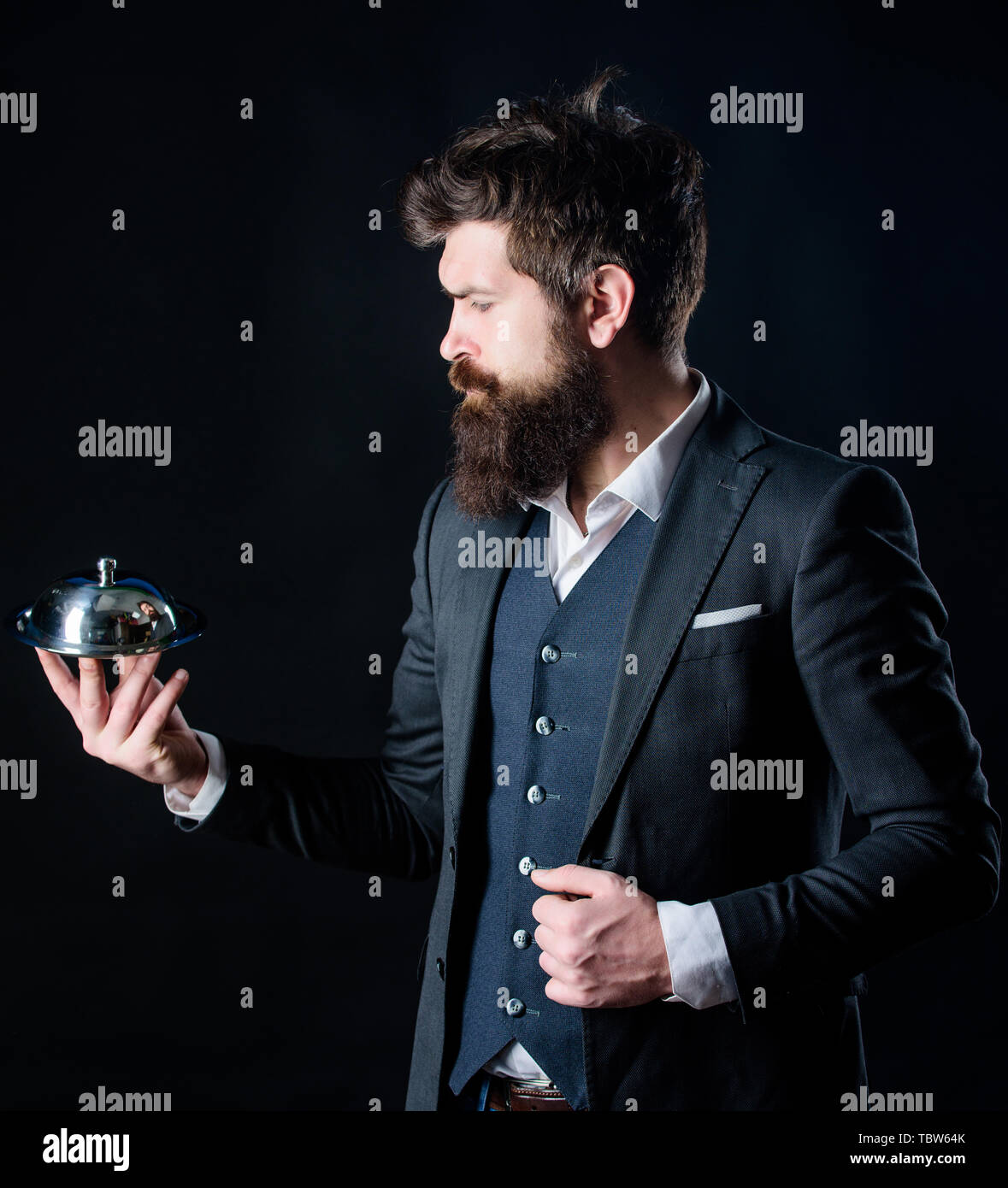 Butler concept. Servant carry metallic cloche. Man well groomed ...