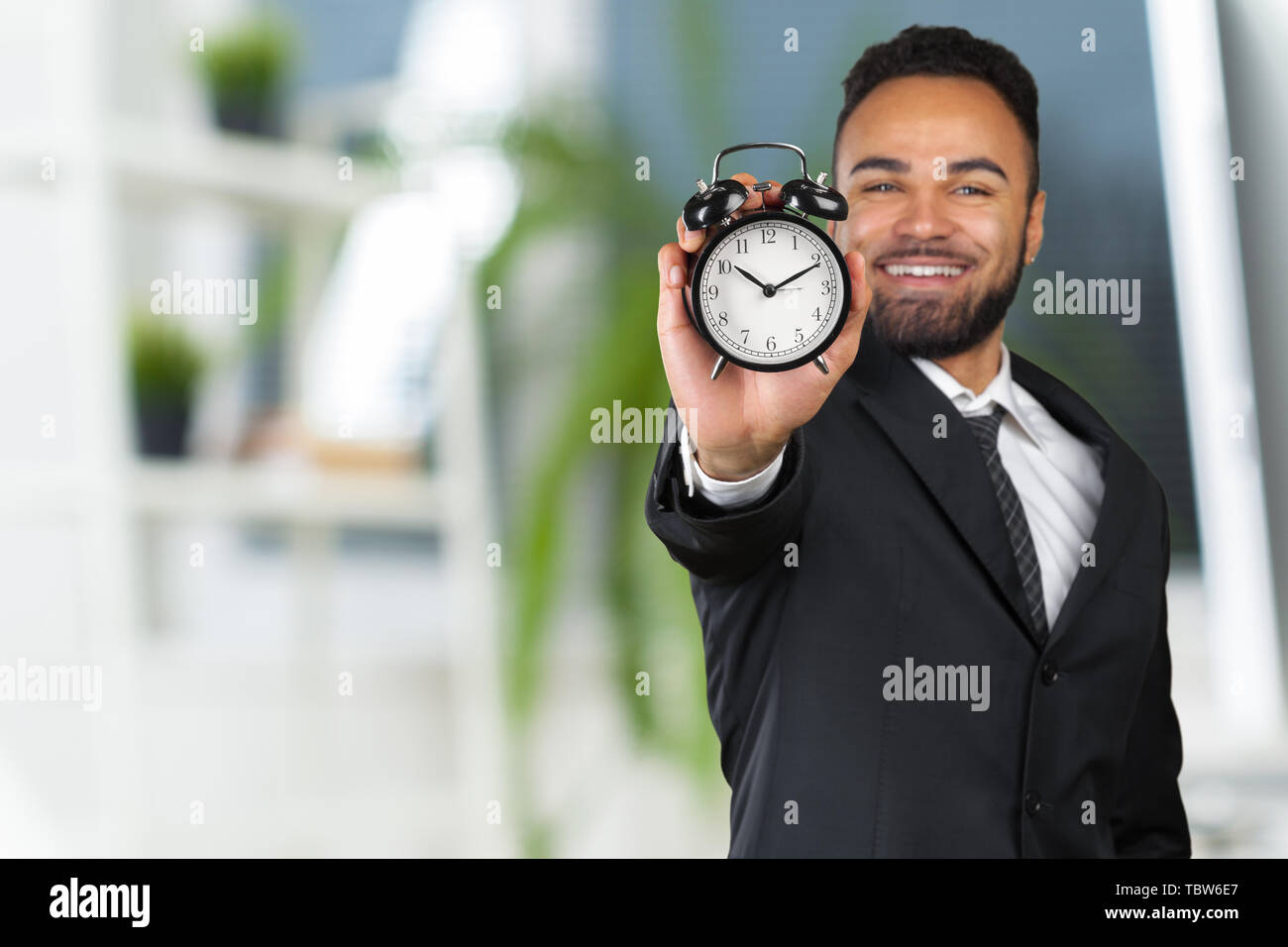 Black businessman with alarm clock. Time management concept Stock Photo ...