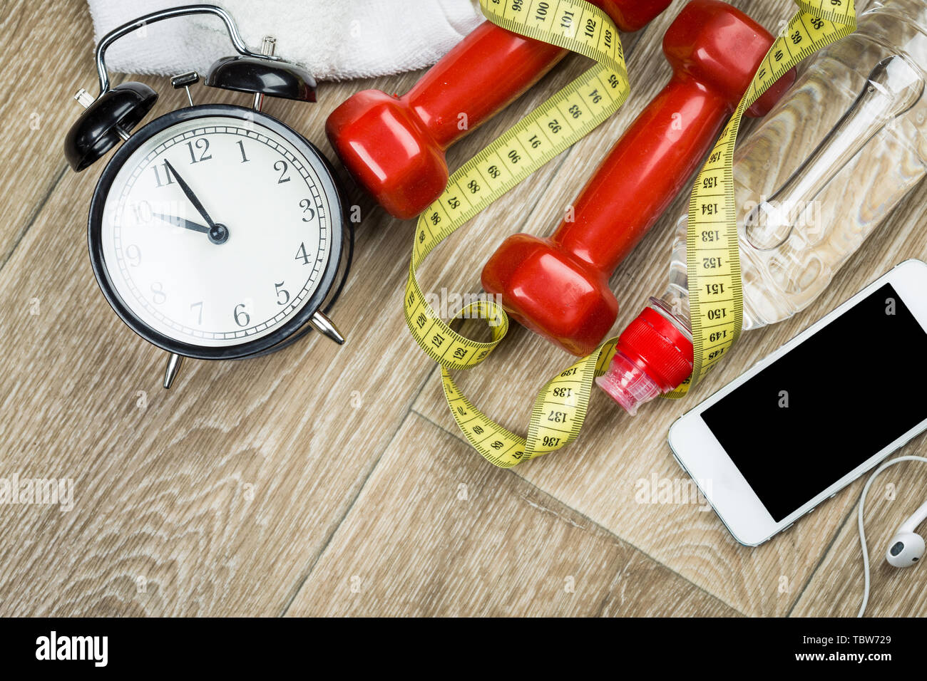Time for exercising concept. Clock and dumbbell Stock Photo - Alamy