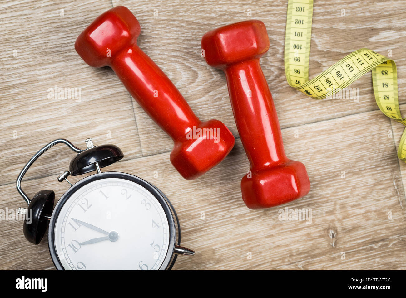 Time for exercising concept. Clock and dumbbell Stock Photo - Alamy