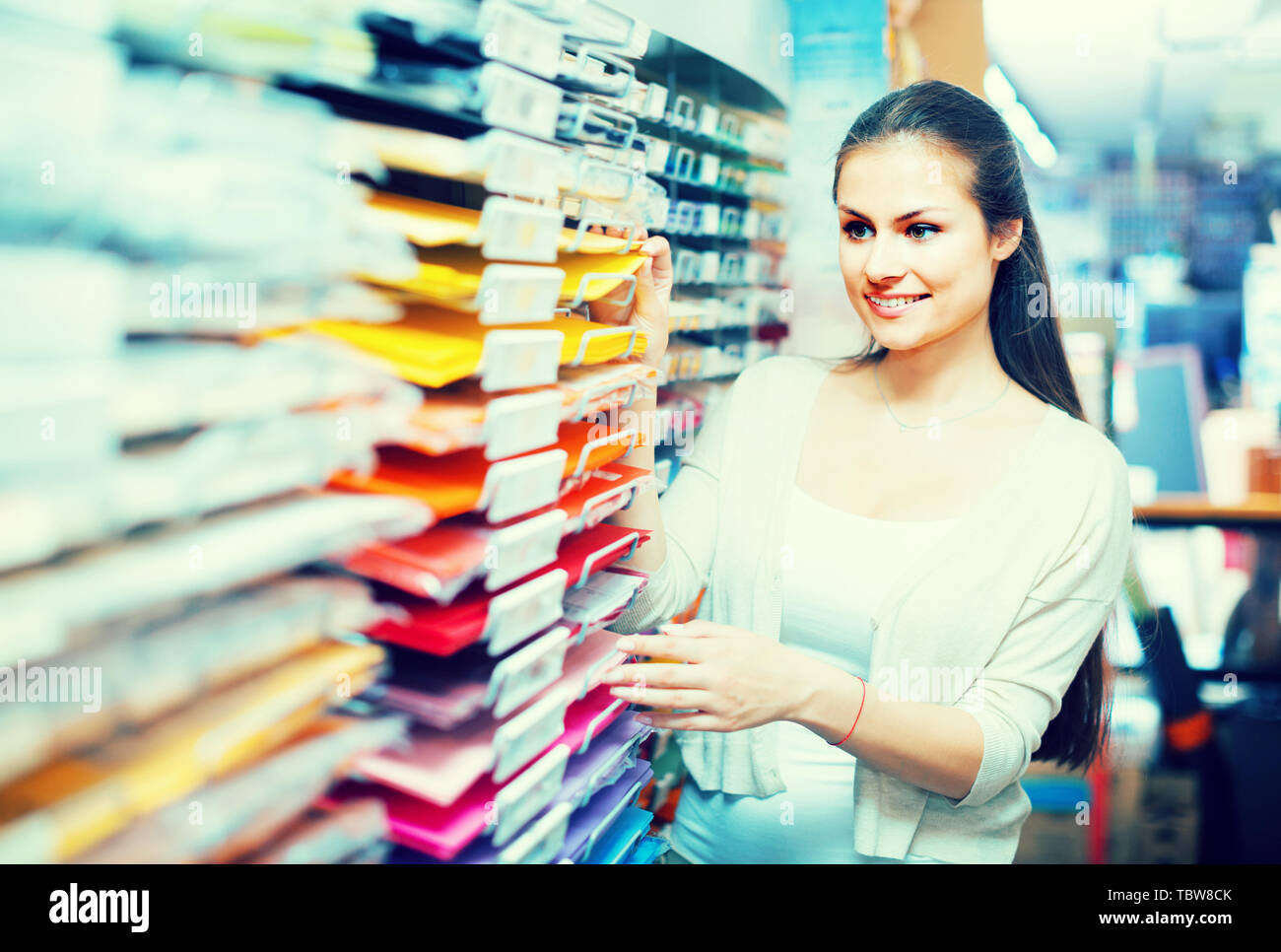 american woman choosing paper for drawing in art shop Stock Photo - Alamy