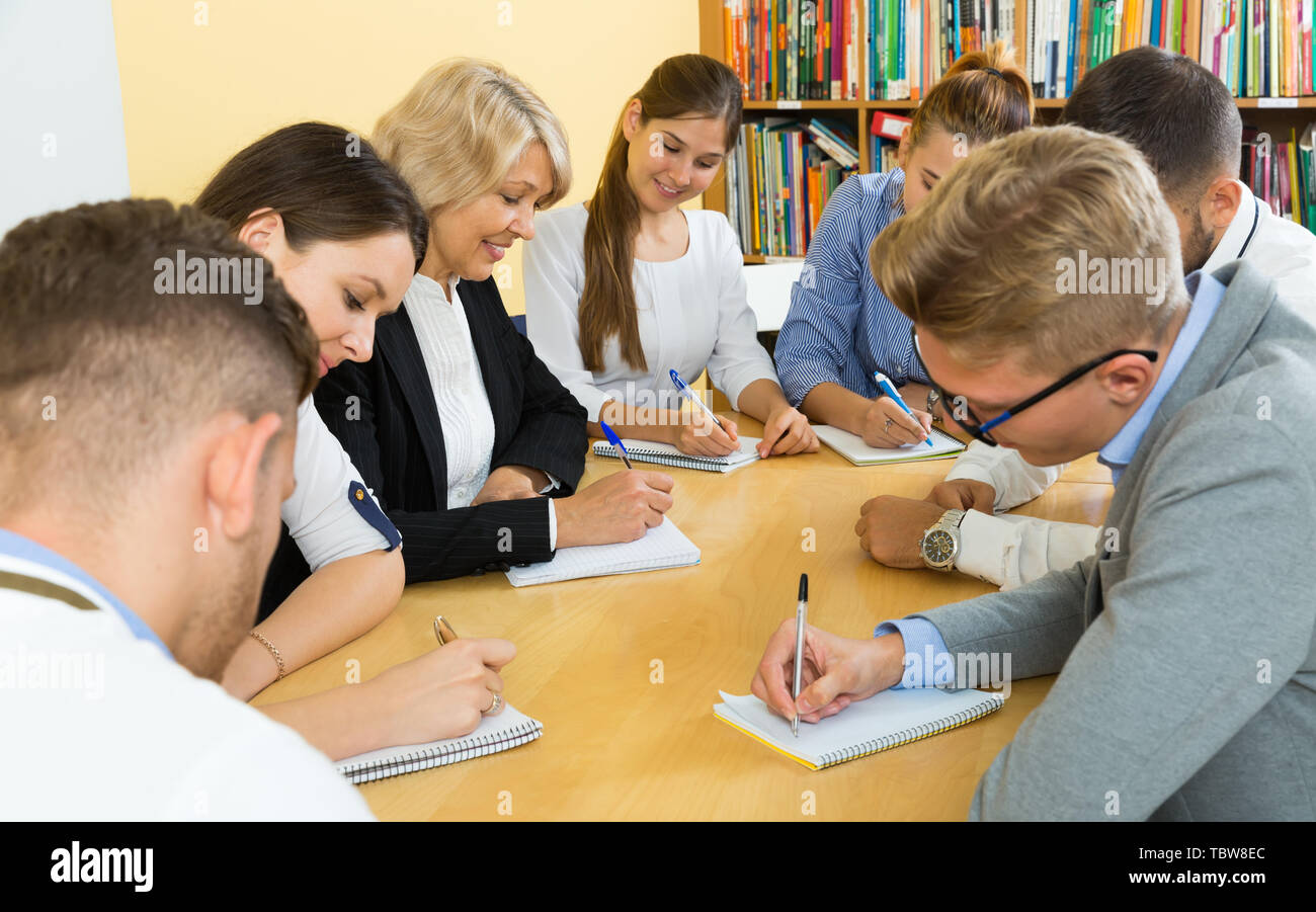 Students with educator doing group study together in auditorium ...