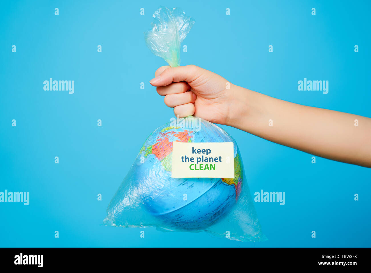 Woman holds in hands plastic bag and planet earth with text sticker ...