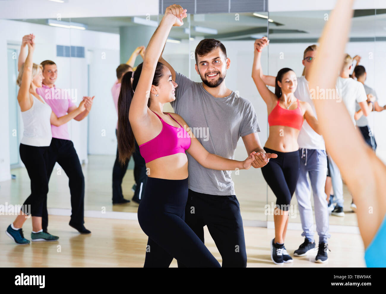 Happy cheerful positive people of different ages having dancing class ...