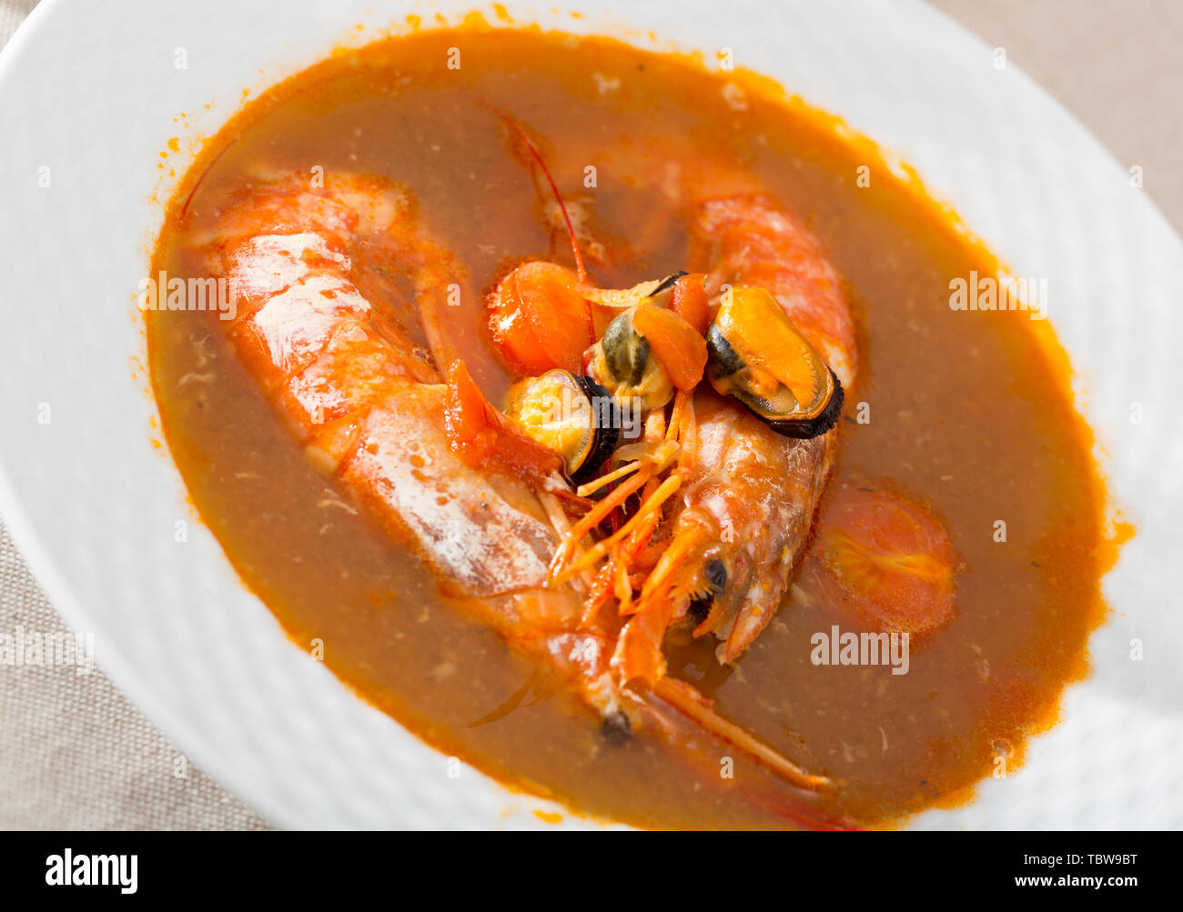 Spicy seafood broth with king prawns and shellfish Stock Photo - Alamy
