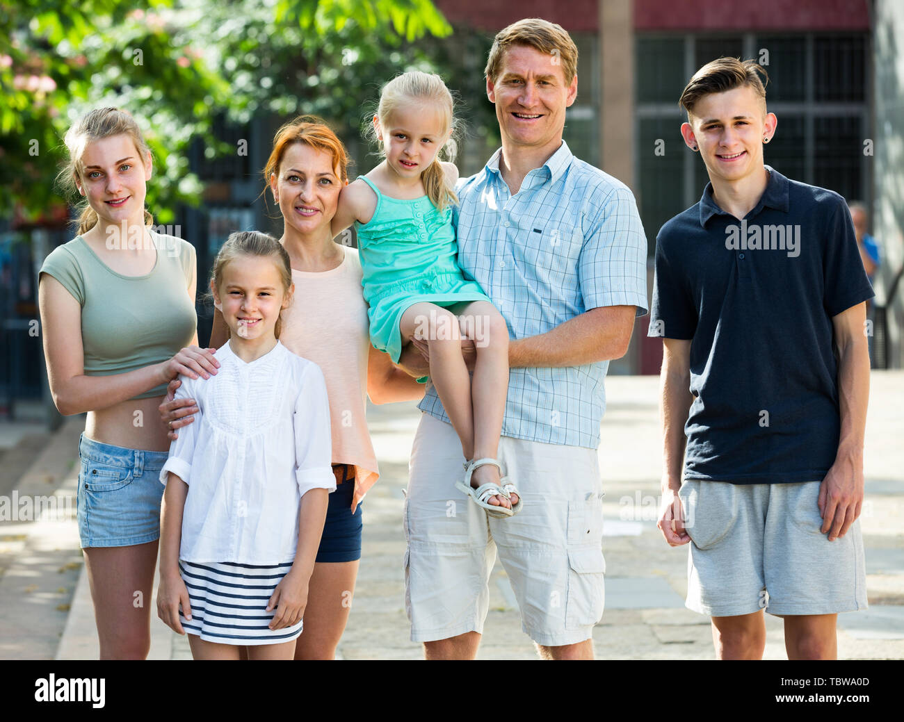 European family of six people happily walking together in summer city ...