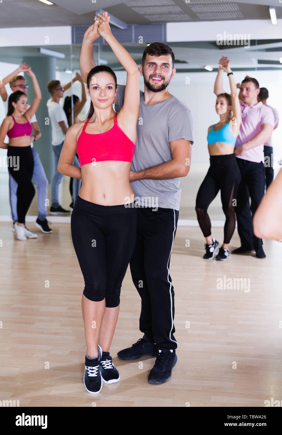 Group of positive smiling young dancing salsa in club Stock Photo - Alamy