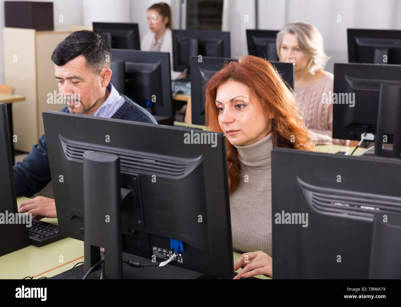 Computer lessons for adults. Mature woman learning to use computer in ...