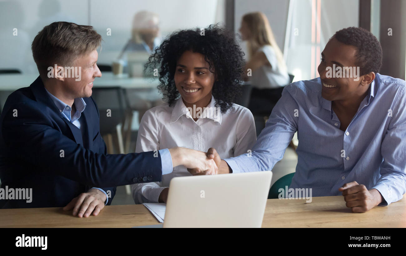 Confident businessman shaking hand of African American business partner ...