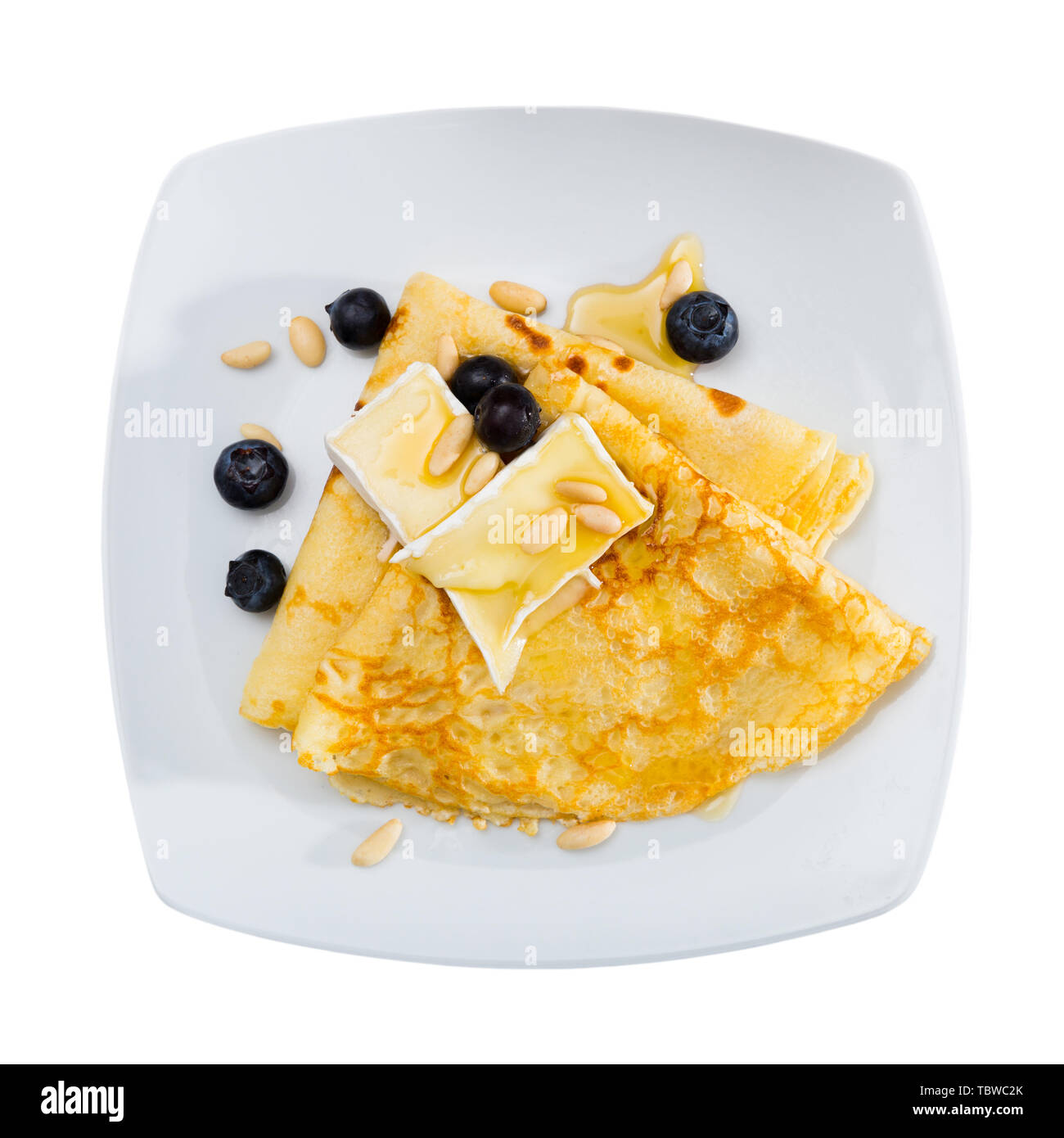 Top view of delicate crepes served with slices of soft brie, honey ...