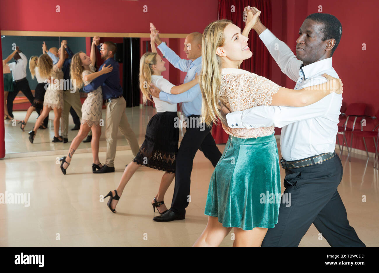 Portrait of positive adult couples dancing tango together in modern ...