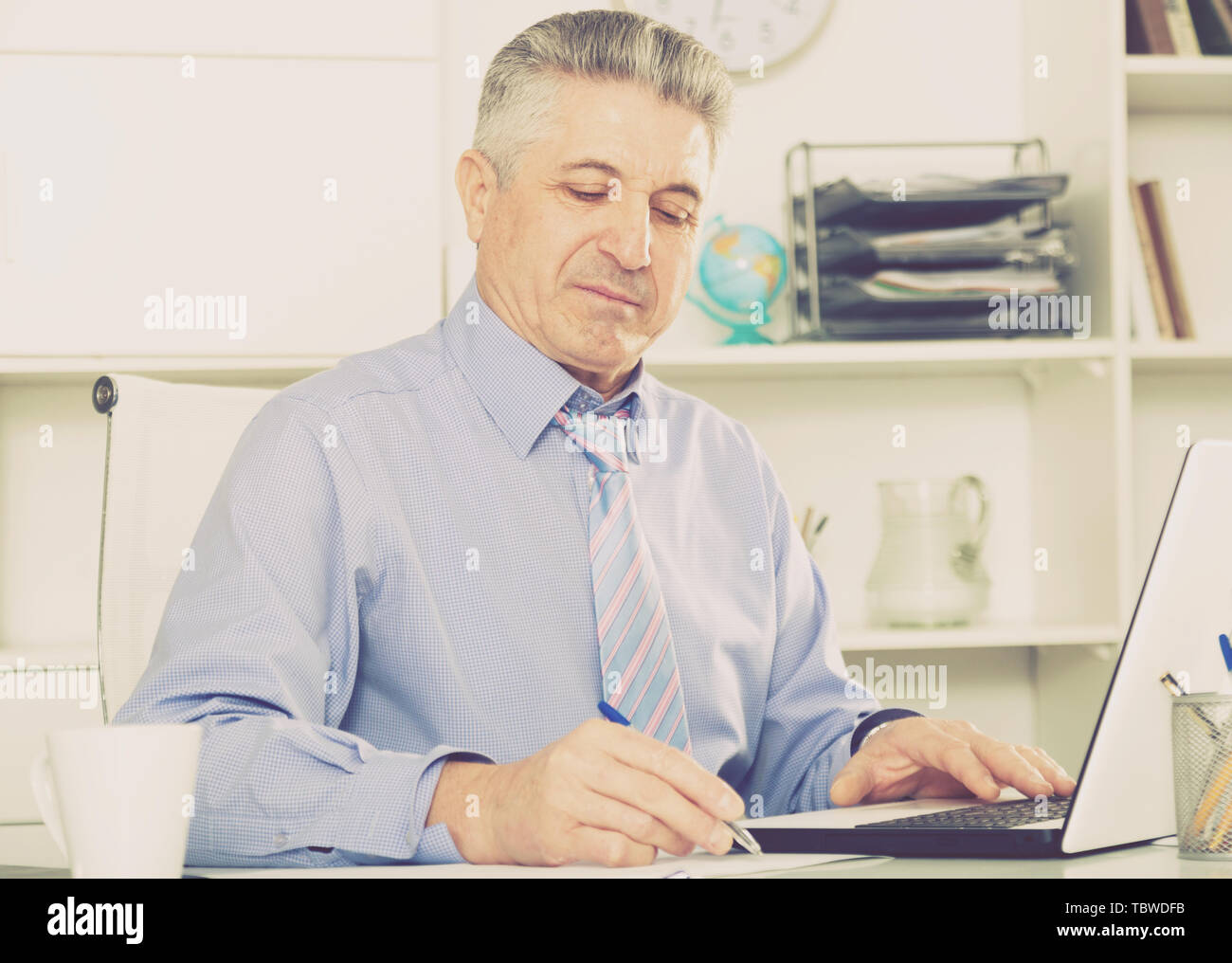 Mature lawyer examines important documents in the office of the law ...