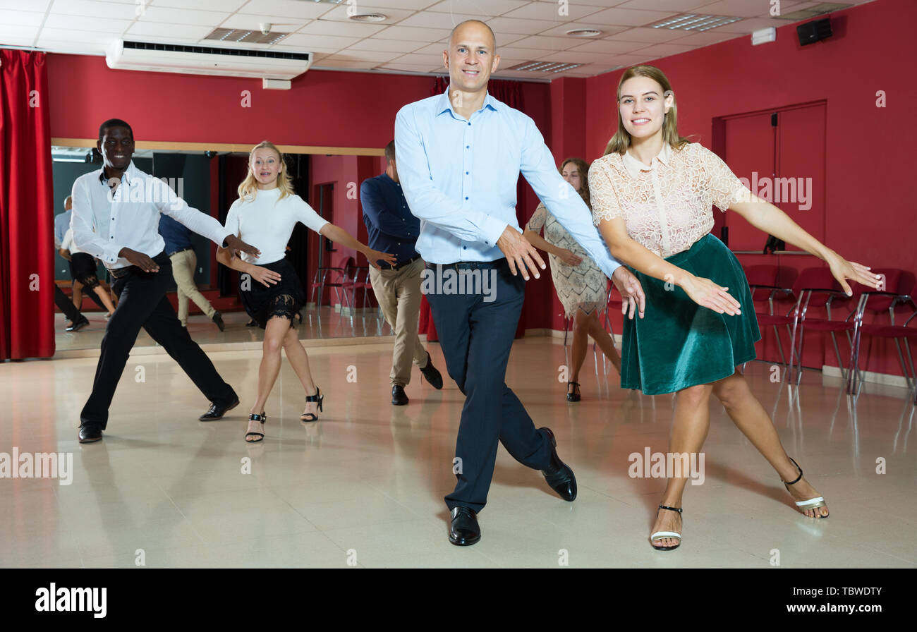 Adult dancing couples enjoying rhythmic tap dance in dance studio Stock ...