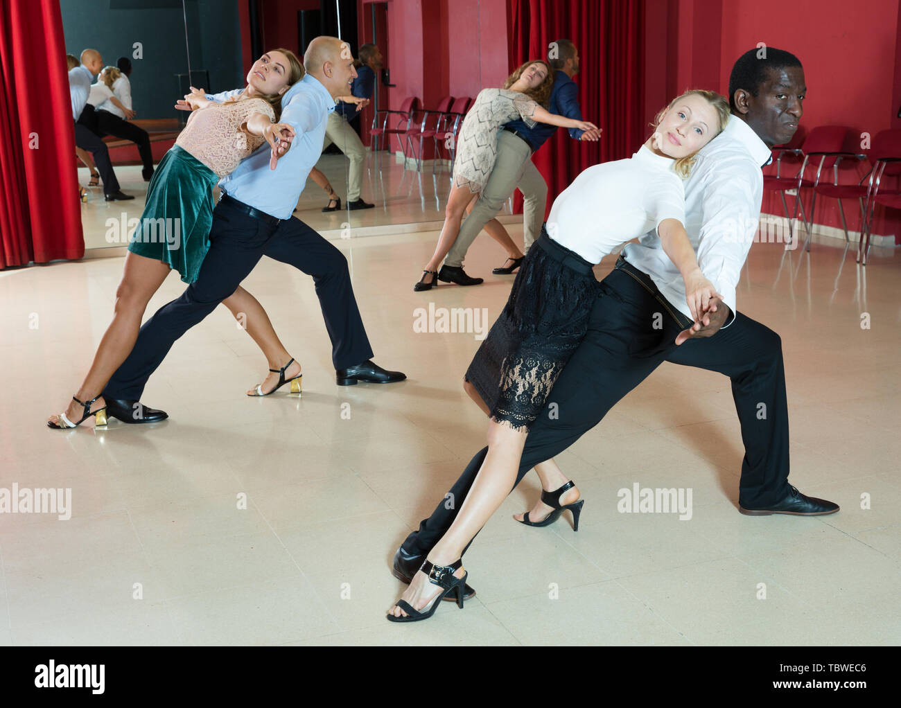 Young positive people dancing samba in pairs in dance hall Stock Photo ...