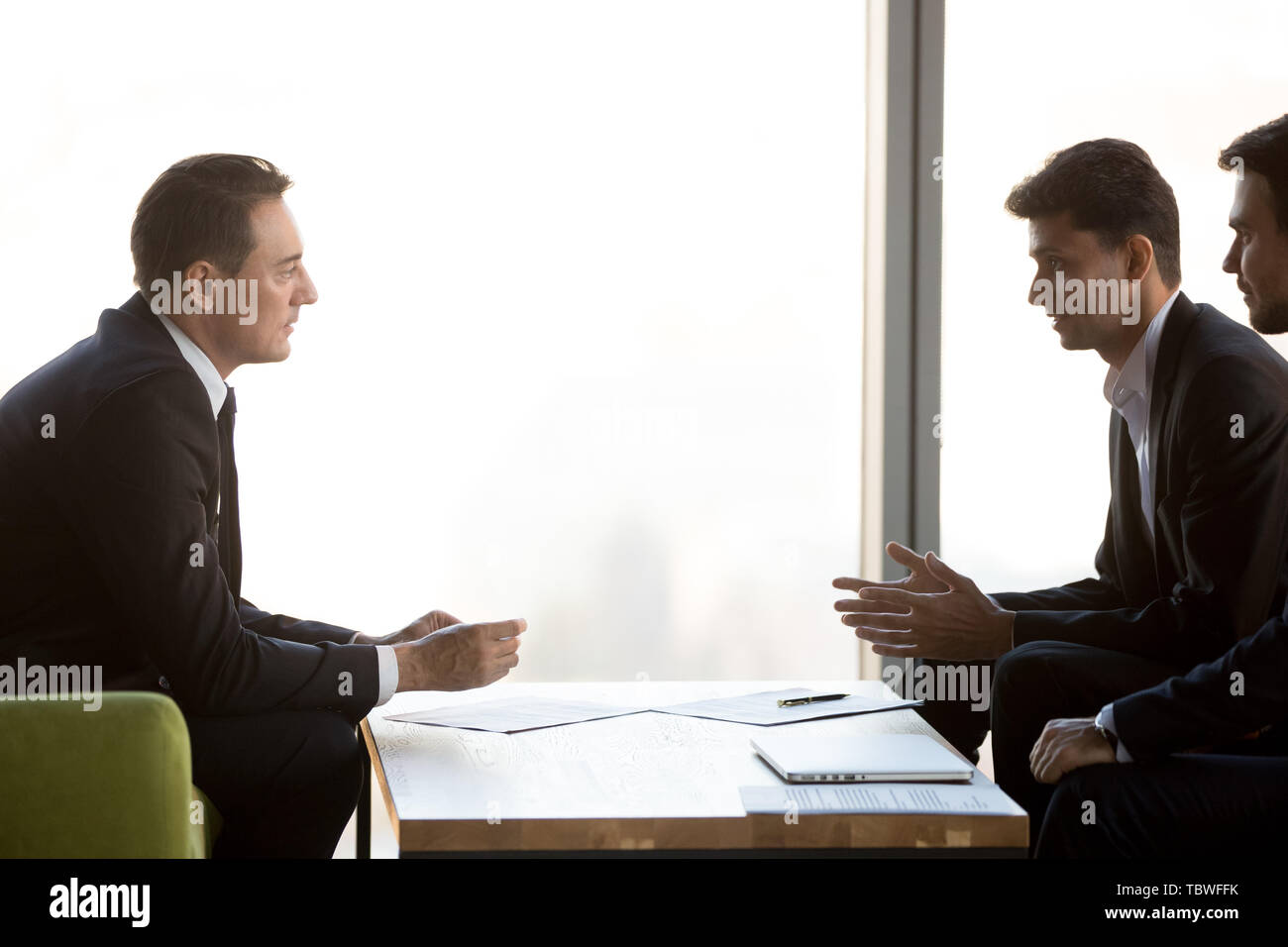 Concentrated businessmen negotiate at meeting discussing cooperation ...