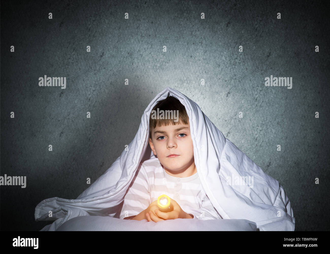 Little child with flashlight hiding under blanket Stock Photo - Alamy