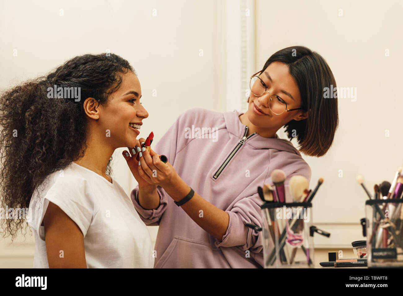 Makeup artist chooses lipstick color for model Stock Photo - Alamy