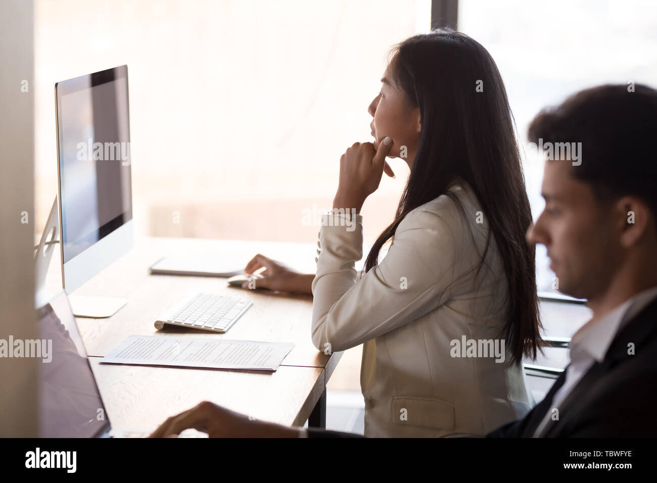 Focused Asian employee busy working at pc in coworking space Stock ...