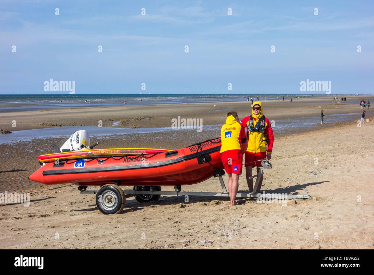 Two beach lifeguards pulling inflatable rescue boat back to base at ...