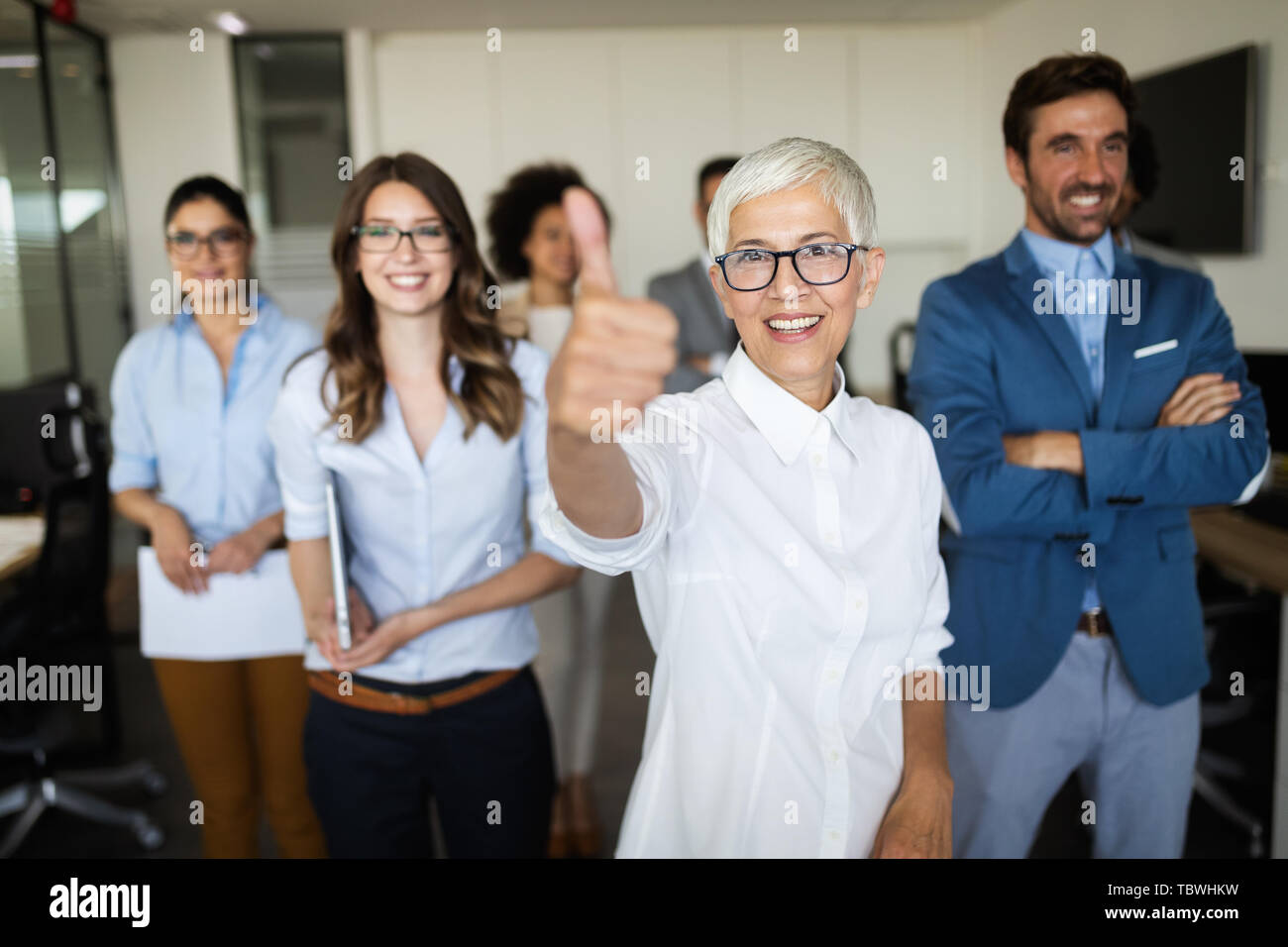 Happy business people celebrating success at company Stock Photo - Alamy