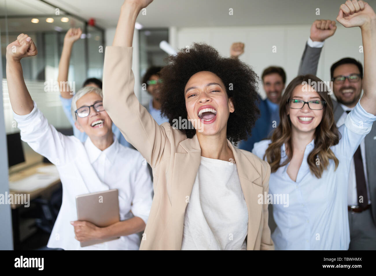 Happy business people celebrating success at company Stock Photo - Alamy
