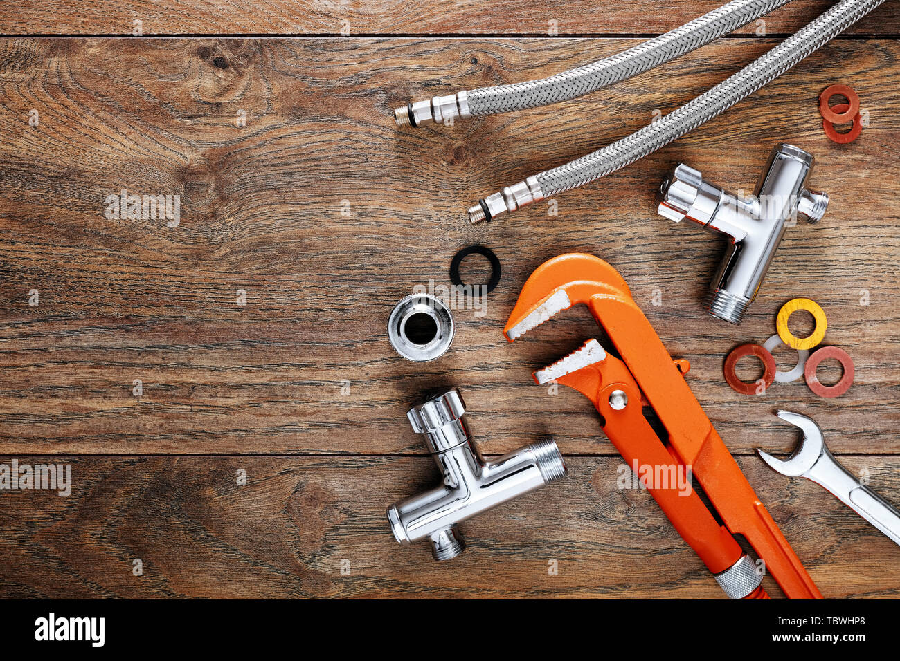 Set of plumbing tools on wooden table background. Close up top down ...