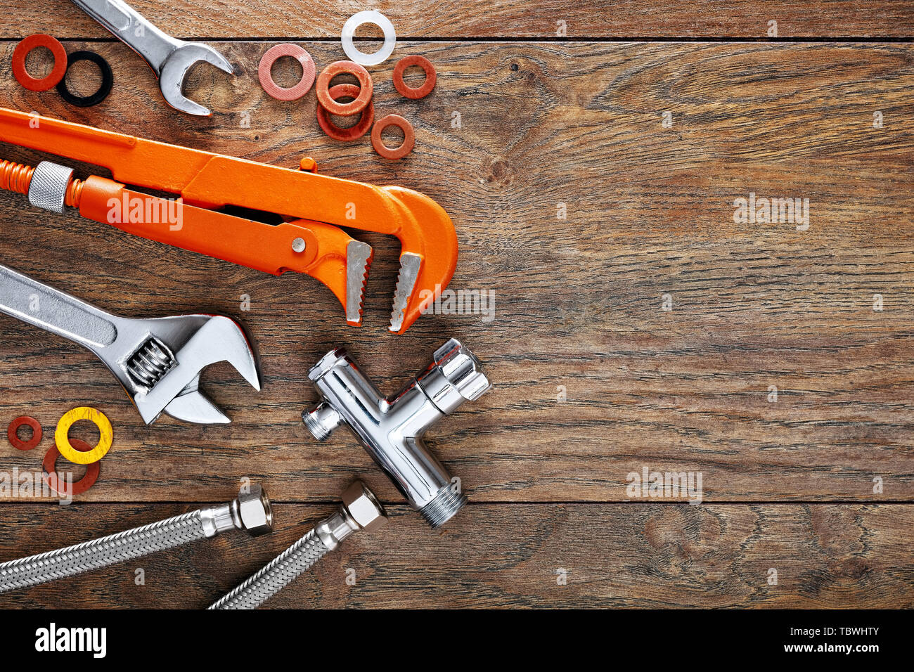 Set of plumbing tools on wooden table background. Close up top down ...