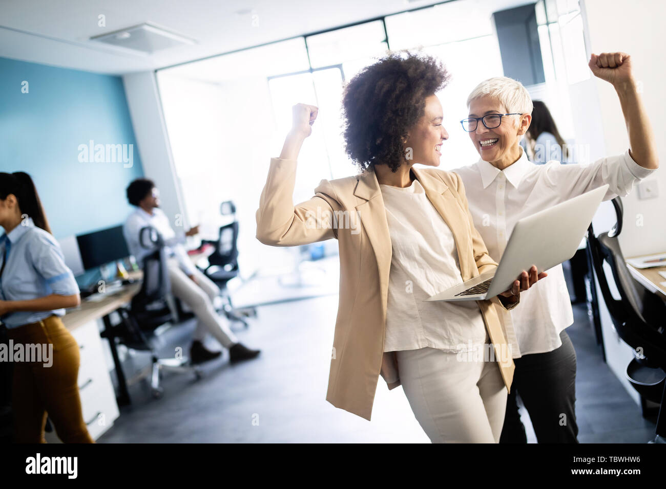 Happy business people celebrating success at company Stock Photo - Alamy