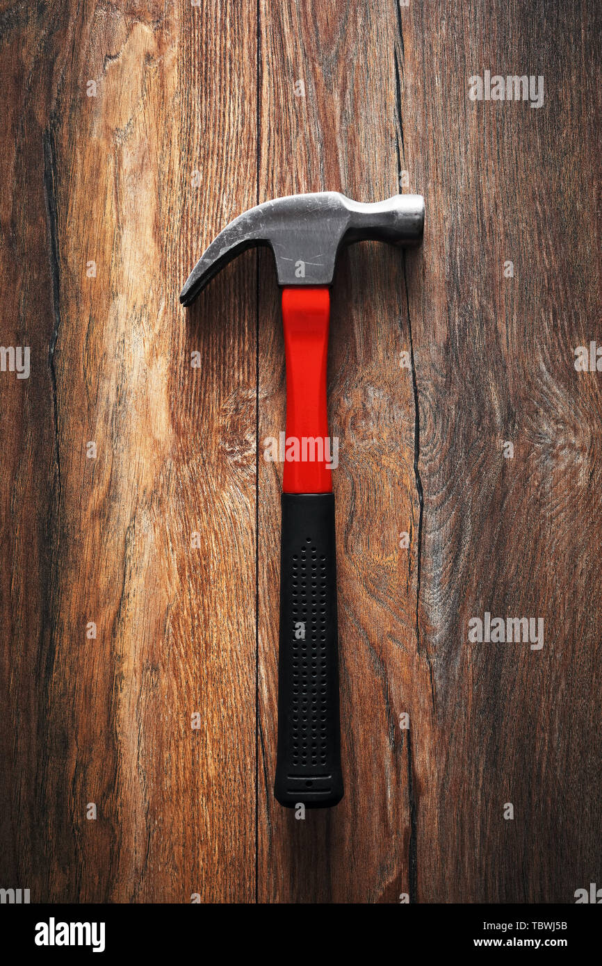 Hammer with red and black handle on vintage wooden background. Top down ...