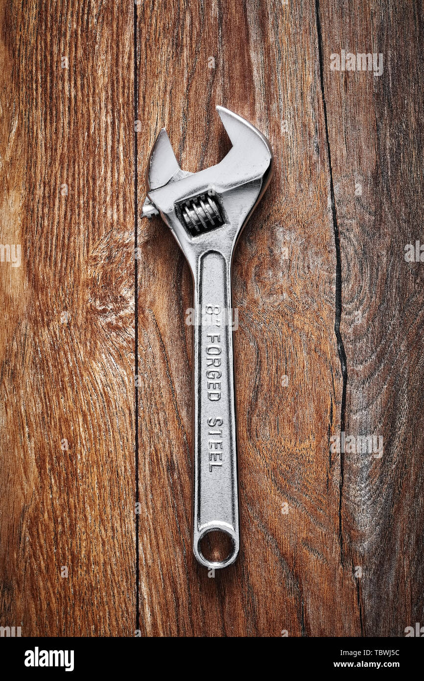 Adjustable wrench on vintage wooden table background. Top down view ...