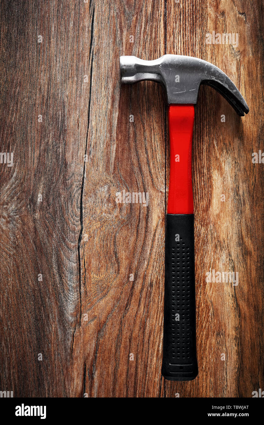 Hammer with red and black handle on vintage wooden background with copy ...