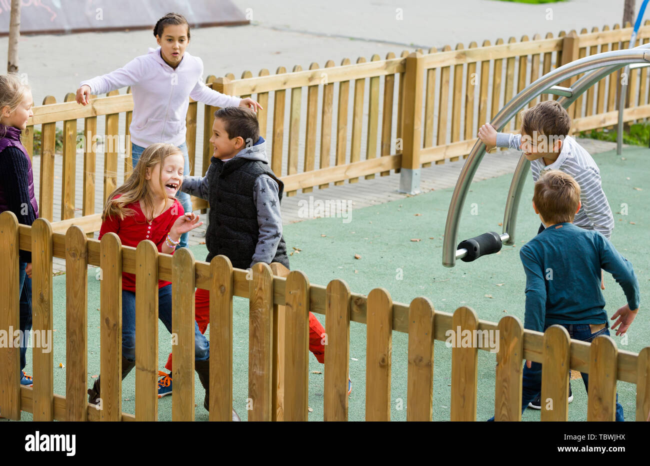 Positive kids running around while playing at Tag in street Stock Photo ...