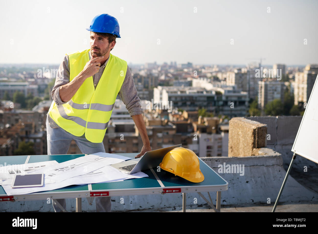 Young male construction specialist engineer reviewing blueprints at ...