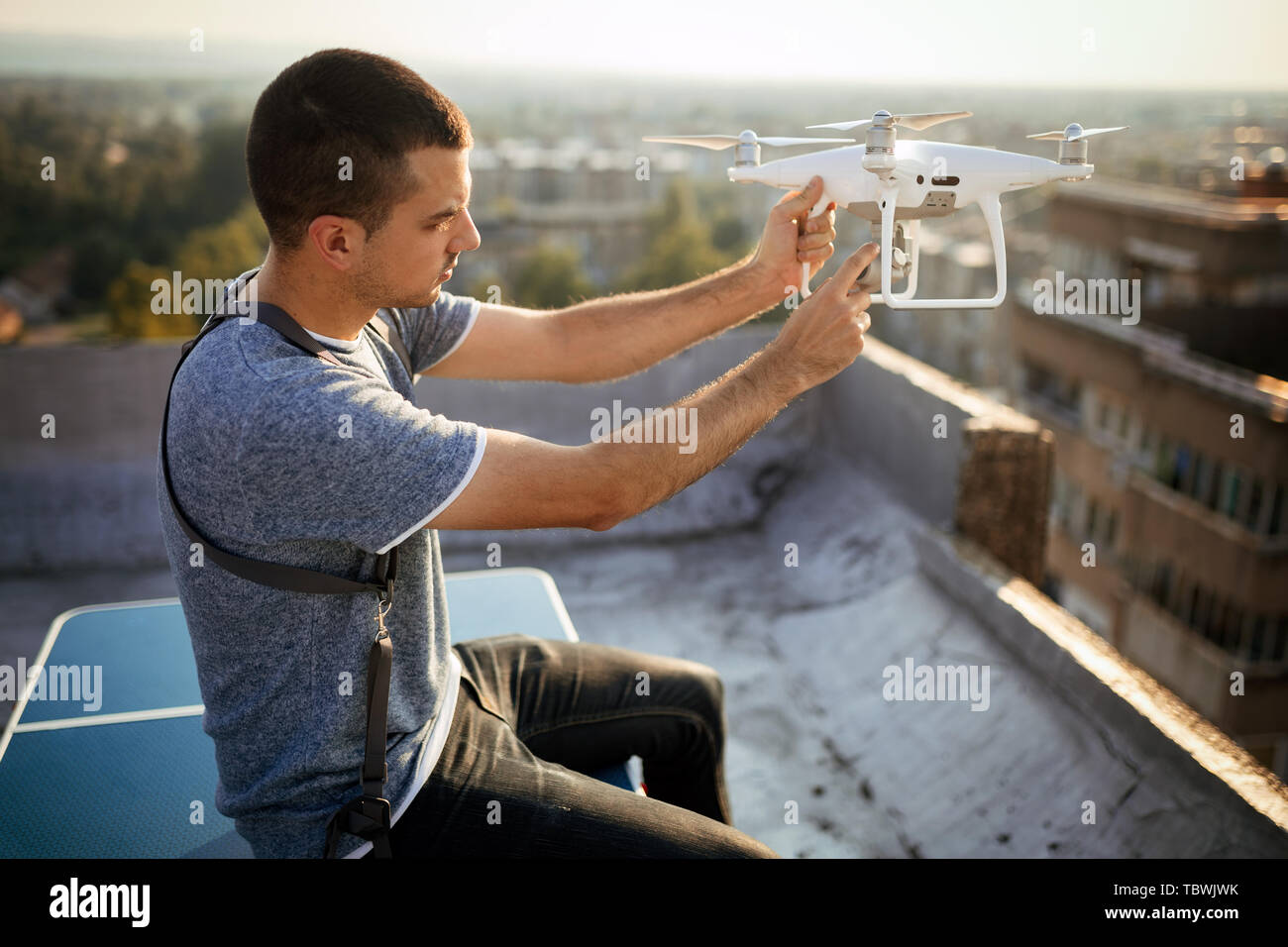 Young technician flying UAV drone with remote control on rooftop Stock ...