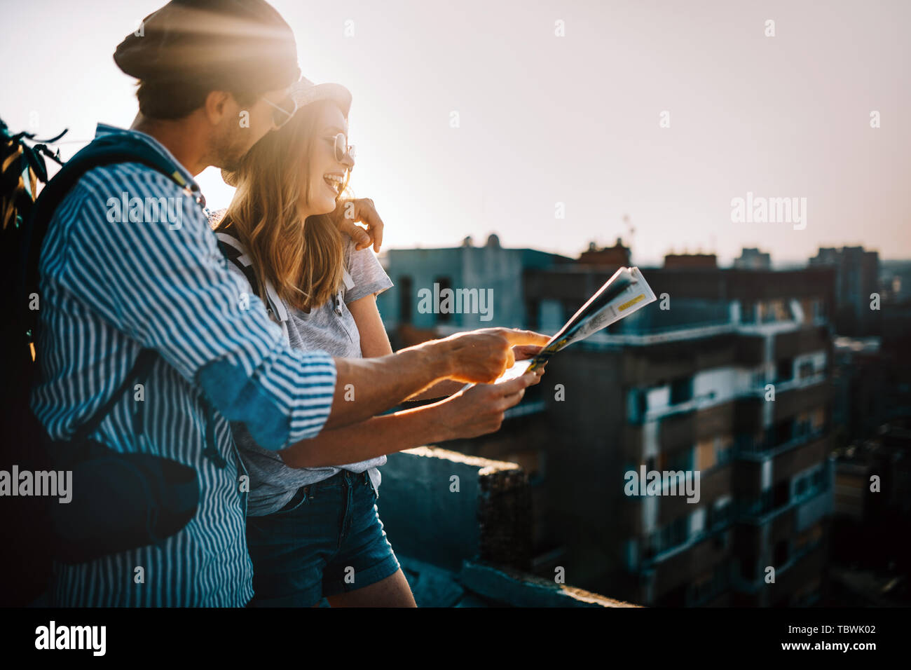 Happy young couple of travellers holding map in hands Stock Photo - Alamy