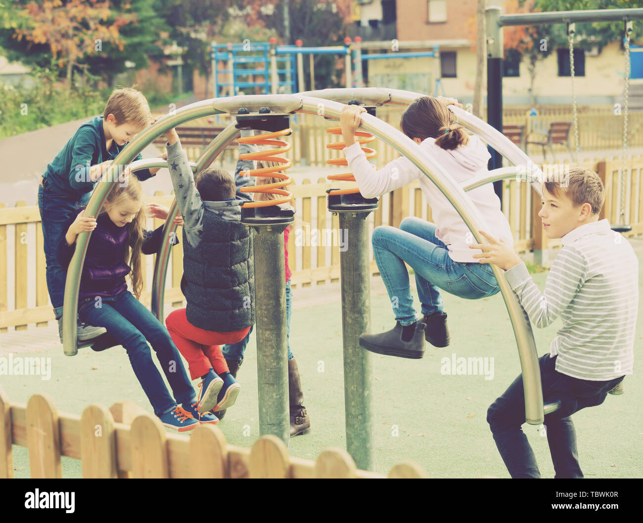 Smiling children playing on swing at playground in park Stock Photo - Alamy