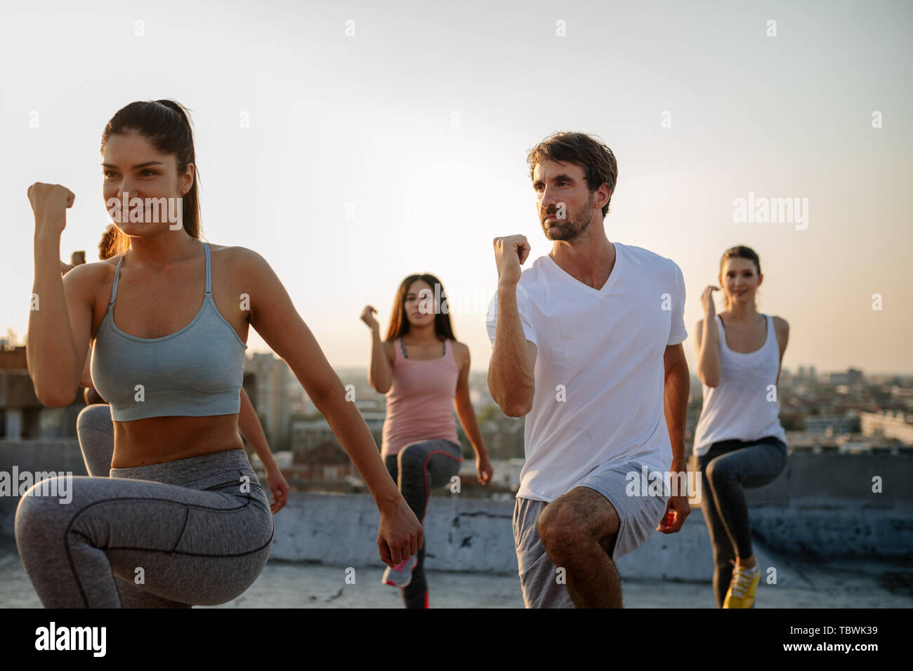 Group of fit healthy friends, people exercising together outdoor on ...