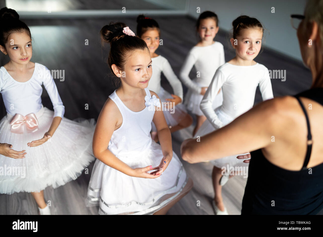 Group of fit happy children exercising ballet in studio together Stock ...