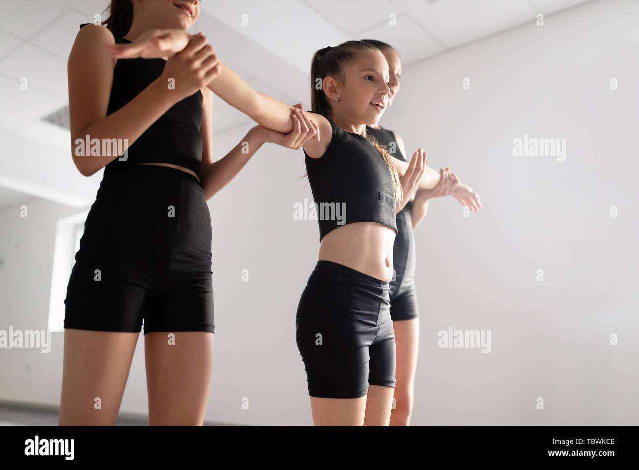 Group of fit happy children exercising dancing and ballet in studio ...
