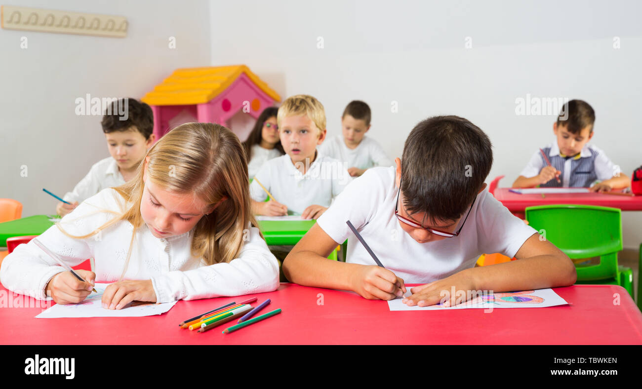 Portrait of diligent focused pupils studying in classroom at elementary ...