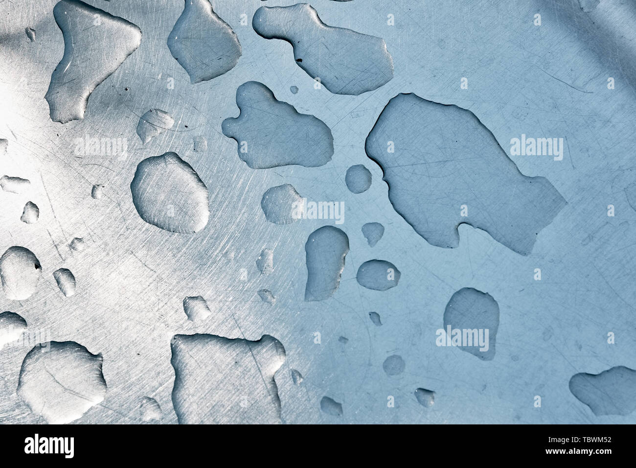 Water droplets on a scratched and worn stainless steel metal surface ...