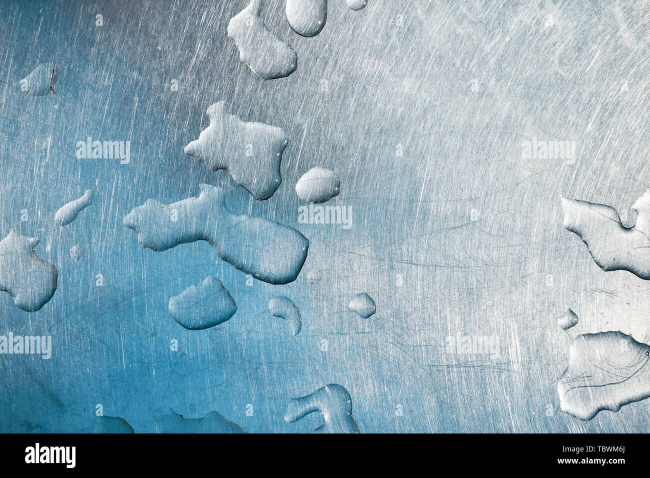 Water droplets on a scratched and worn stainless steel metal surface ...