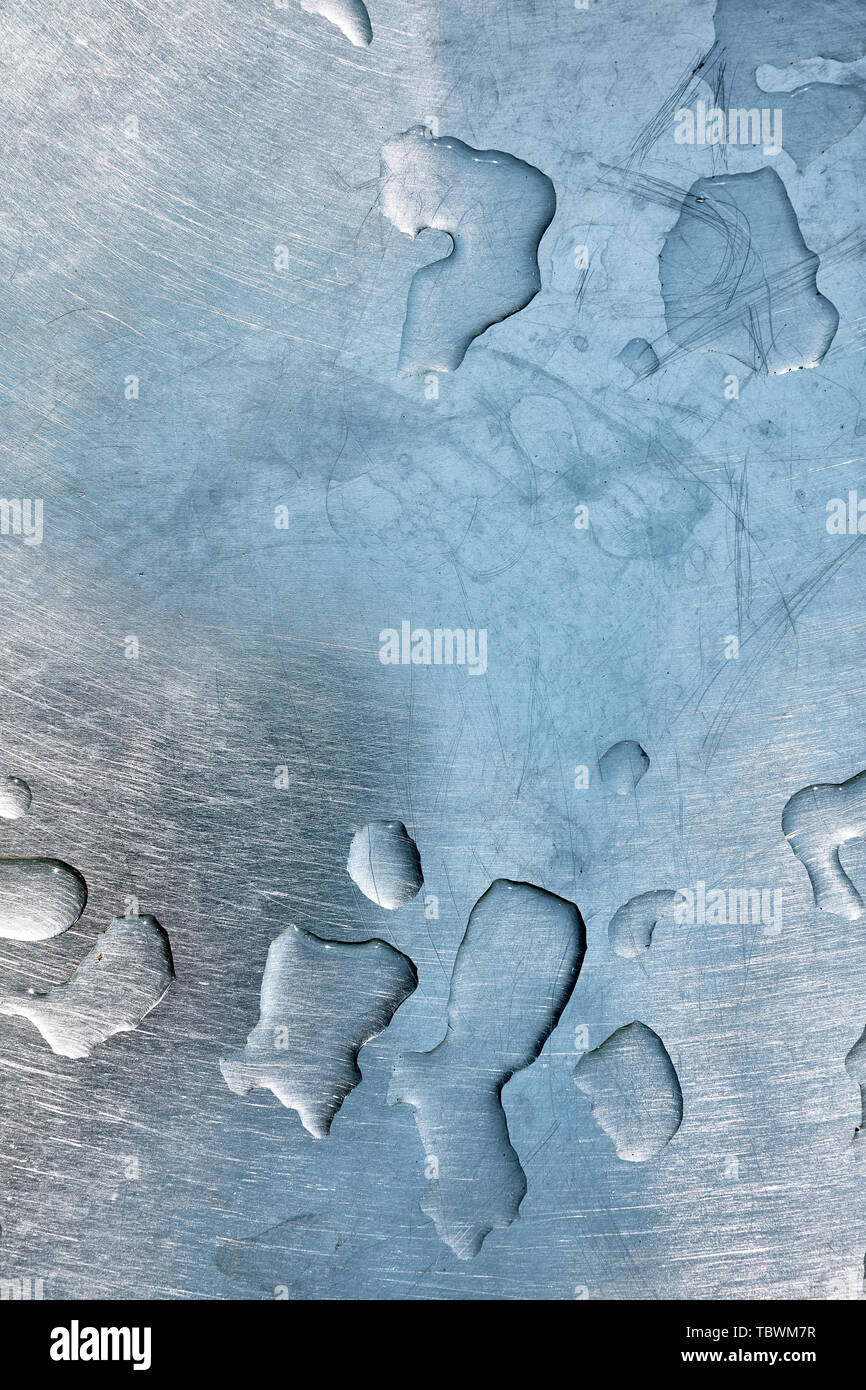 Water droplets on a scratched and worn stainless steel metal surface ...