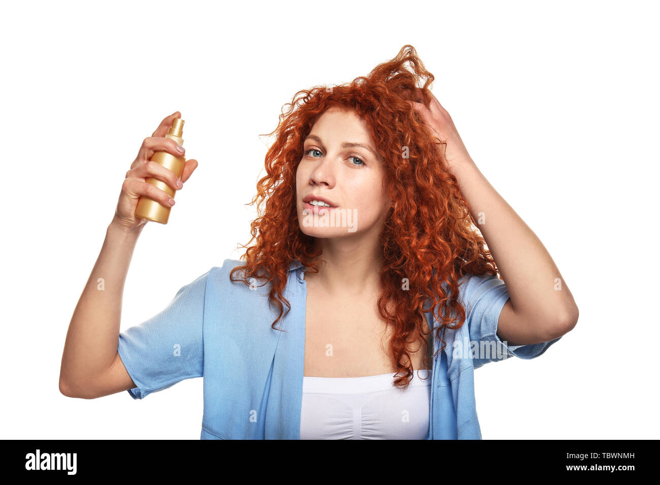 Beautiful young woman applying hair spray on white background Stock ...