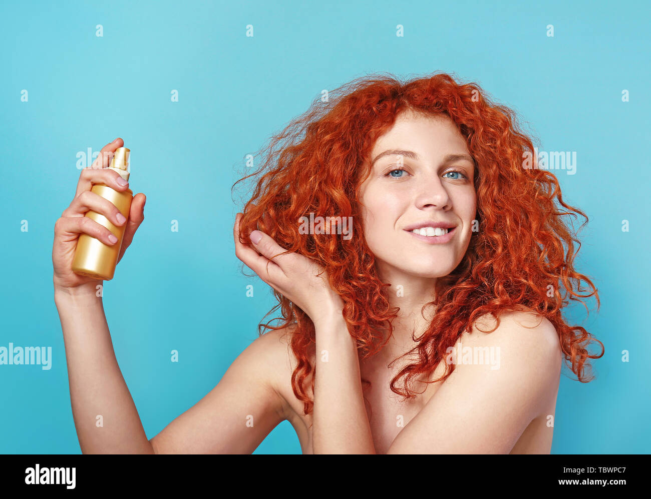 Beautiful young woman applying hair spray on color background Stock ...